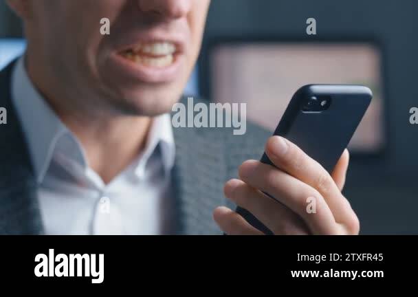 Aggressive businessman talking on a video call on a mobile phone. The ...