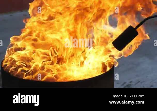 Hot flame over a black pot with a flamethrower nozzle aiming a stream of fire Impressive view of ...