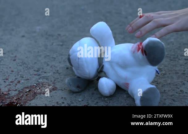 Grieving mother holding bloody teddy bear of dead child after terrible ...