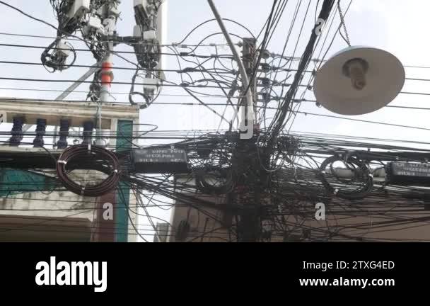 Mess of power lines in Thailand. From below mess of electrical wiring ...