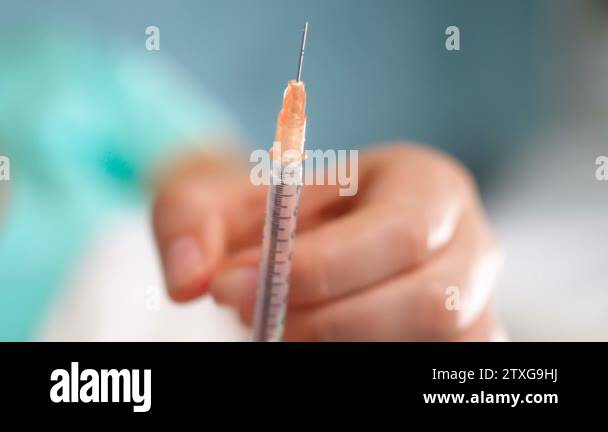 Closeup slow motion video of hitting syringe with finger to get rid of ...