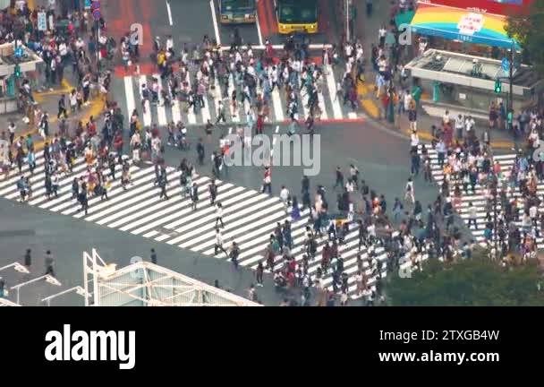People cross the famous intersection in Shibuya, Tokyo, Japan one of ...