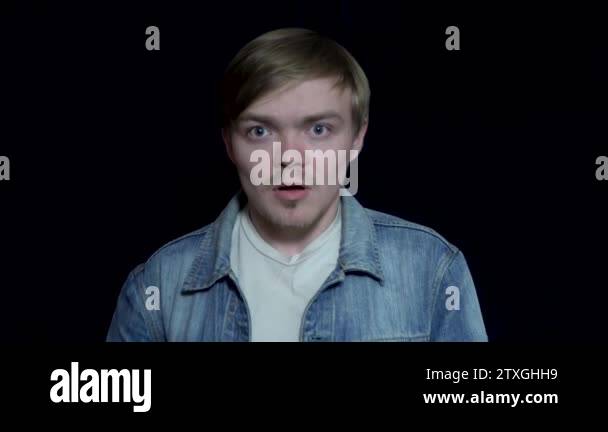 Young man is surprised and closes mouth with palm. Man shocked by what ...