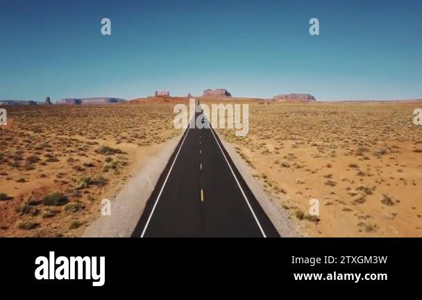 Drone follows car moving along iconic American desert highway road in ...