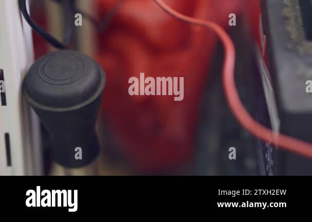 The car battery is charging. Only the positive terminal is visible in ...