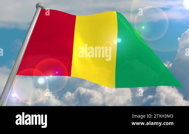 The flag of the State of Guinea develops in the wind against a blue sky ...
