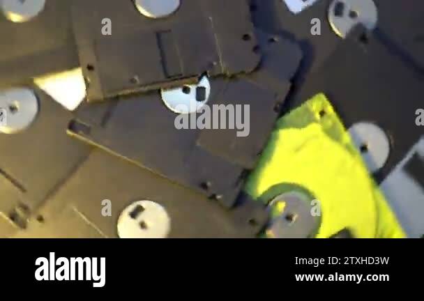 pile of old style data transfer floppy discs, rotating spinning ...
