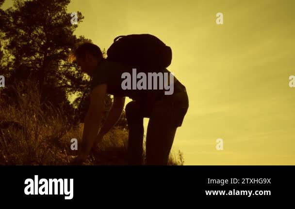 father reaches out a helping hand to children helping to climb mountain ...
