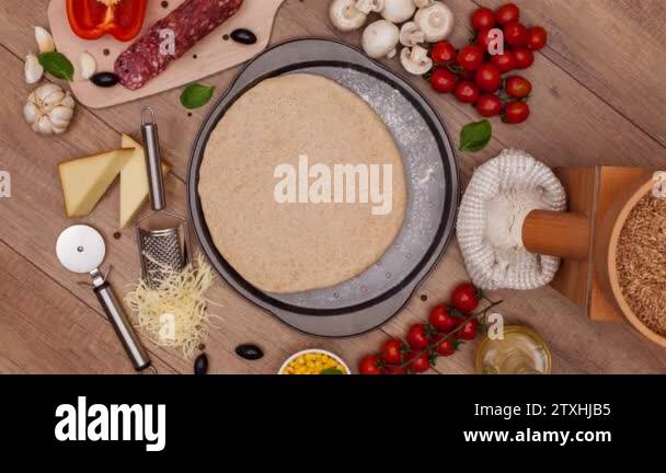 Top view of making a pizza with ingredients appearing on the slowly ...