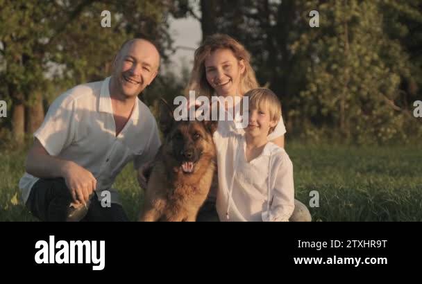 Happy family with a dog in nature. 7 year old boy with his parents ...