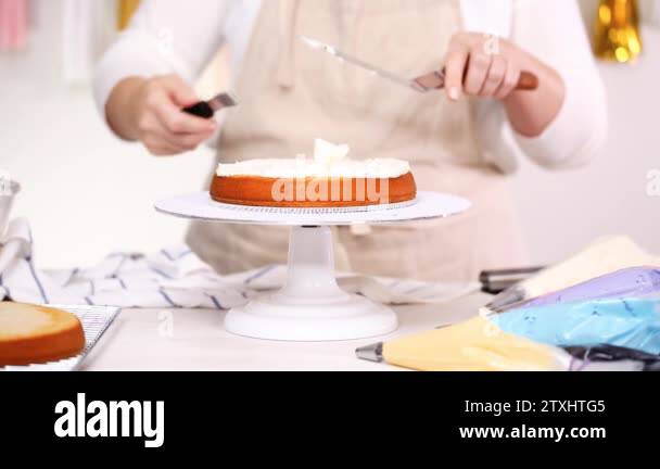 Step by step. Pastry chef stacking cake layers with buttercream ...