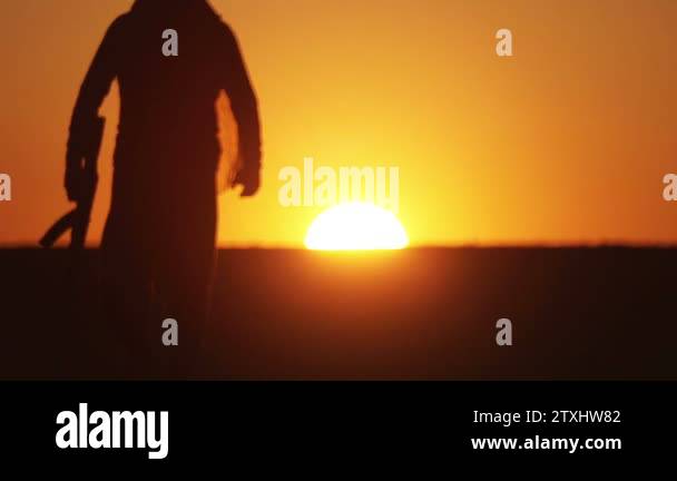 Islamic warrior with Kalashnikov at sunset day. Muslim fighter is ...