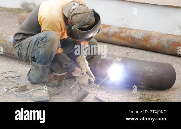 Welding pipeline. Welder worker welding pipe by electrode. Electrodes ...