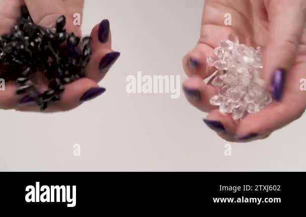 Two woman's hands holding black and crystal beaded strings and turning ...