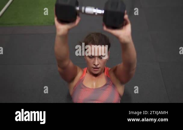 Fitness woman doing weighted sit-ups workout in gym, hand-held shooting ...