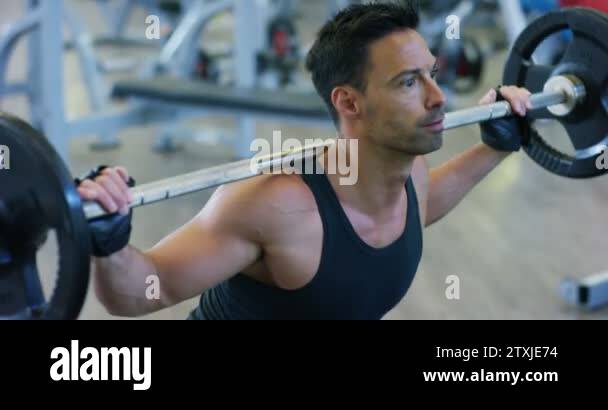 Guy bodybuilder in the gym, works with a barbell, bench press ...