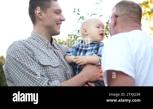 Little grandson kisses grandfather. Three generations of the same ...