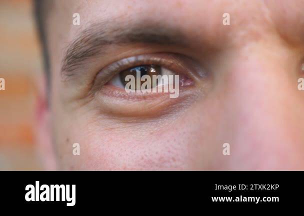 Close up brown eye of man staring and blinking with a happy sight ...