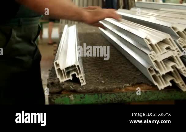 Production of pvc windows, male worker punctures the details of a pvc ...