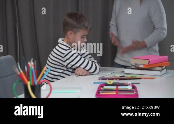 Female Caucasian tutor explaining mistakes to her student. Little boy ...