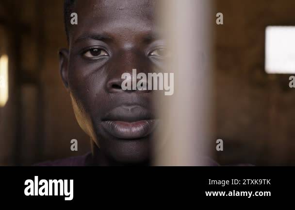 Sad lonely young african man behind prison's bars. Migration,illegal ...