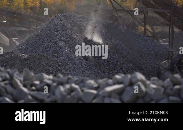 Gravel, rubble falling in a pile with conveyor belt. Industrial ...