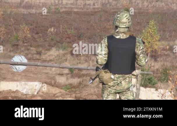 Close-up of an armed soldier. Armed soldiers patrol the territory. A ...
