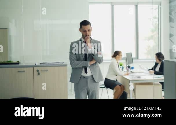 Nervous young man in smart suit is waiting for job interview in modern ...