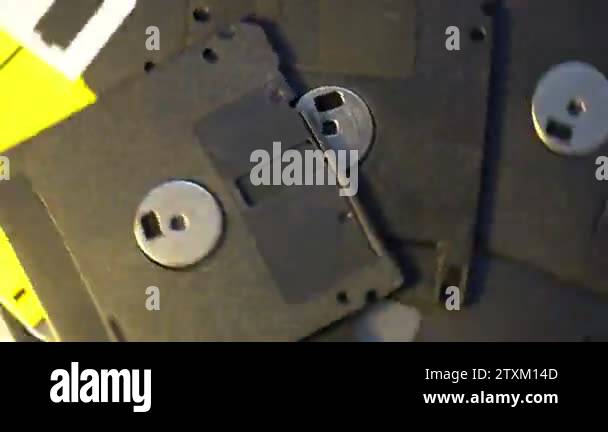 pile of old style data transfer floppy discs, rotating spinning ...