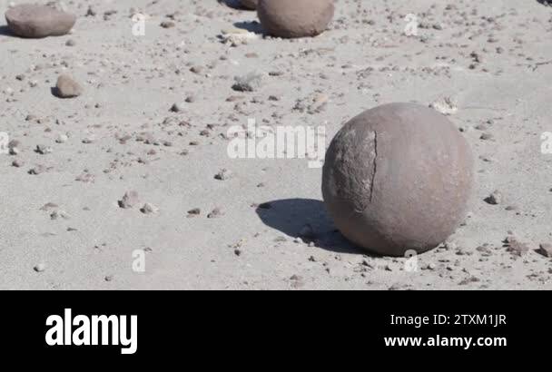 Detail of perfect rounded ball rock, in campo de bochas, over sand geological formation in ...