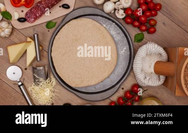 Top view of making a pizza with ingredients appearing on the slowly ...