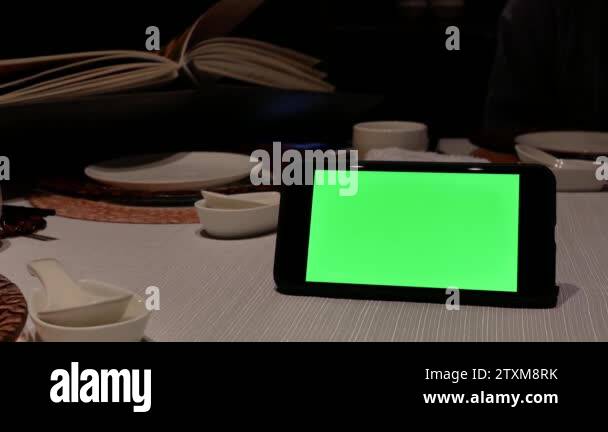 Motion of green screen phone with blur people looking at menu inside restaurant Stock Video ...