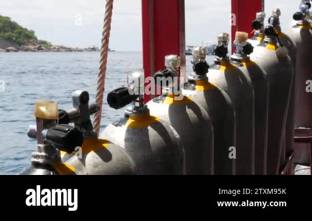 Row of oxygen tanks and diving equipment placed on modern boat in ...