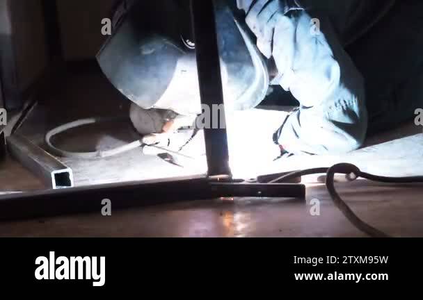 Welder Worker Performs Jump Welding. Worker Welder Performs Arc-Welding ...