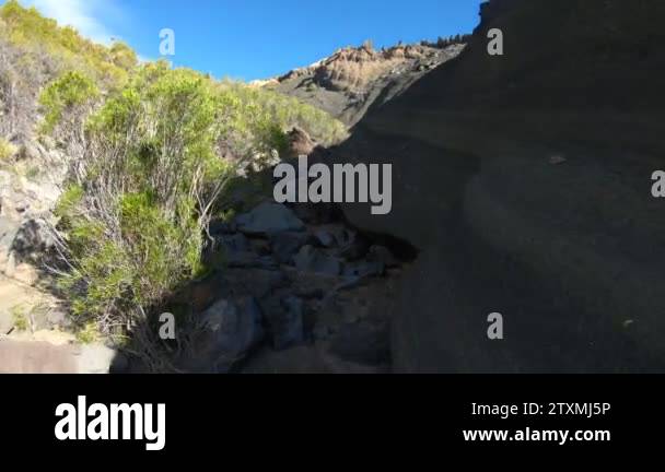 Walking along volcano malacara grey debris, dry river of vocanic depositions. Detail of grey ...