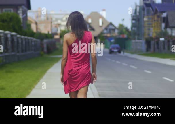 Pretty woman walking down the street, looks back smiling, beautiful ...