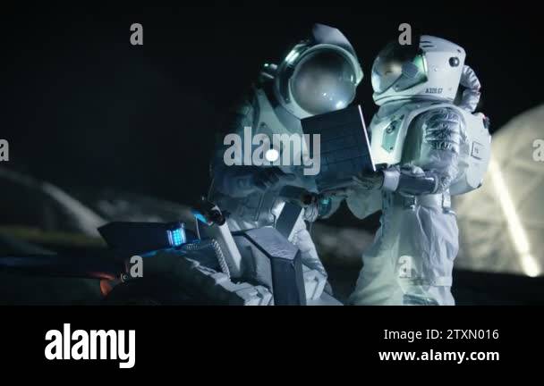 Two Astronauts in Space Suits on an Alien Planet Prepare Space Rover for Planet's Surface ...
