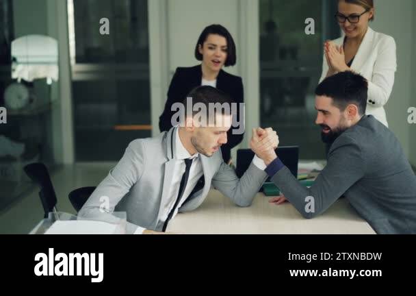 Bearded young people office workers are having fun practising arm ...