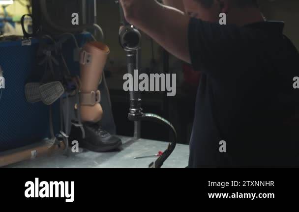 Production of a prosthetic leg. A man creates part of the leg. An ...