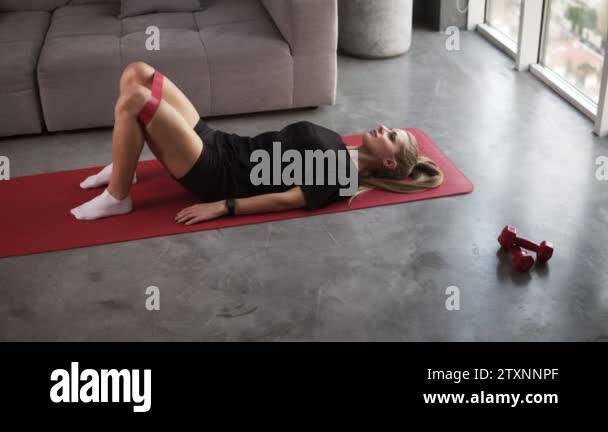 Resistance hoop band exercises. Fit girl training on floor doing Glute ...