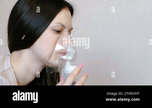 Use nebulizer and inhaler for the treatment. Closeup womans face ...