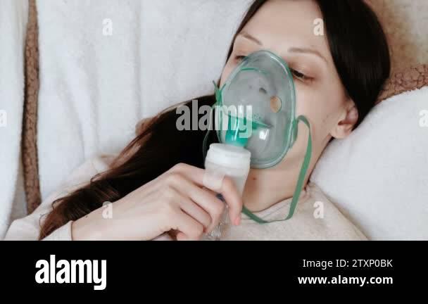 Use nebulizer and inhaler for the treatment. Young woman inhaling ...