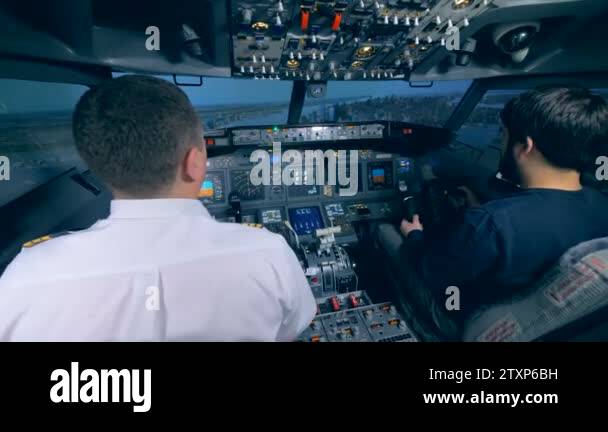 Male pilots sit in a cockpit of a flight simulator, close up Stock ...
