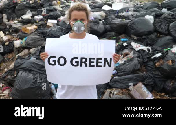 Woman Holding" Go Green" Poster On Waste Dump. Recycle, Eco, Reuse ...