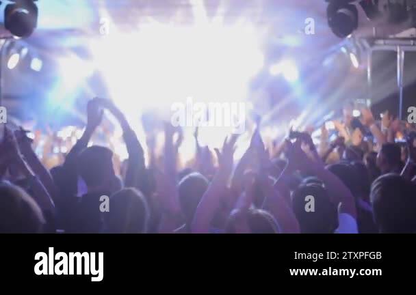 Large group of happy people enjoying rock concert, clapping with raised ...