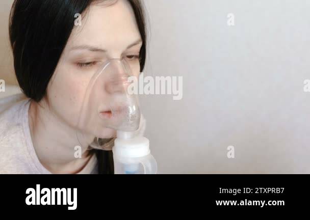 Use nebulizer and inhaler for the treatment. Closeup womans face ...