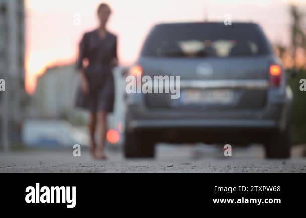 Woman driver putting an emergency stop sign behind broken blurred car ...