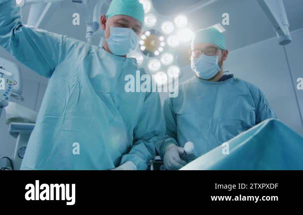 Low Angle Shot In Operating Room of Two Surgeons During the Surgery ...