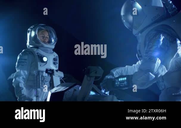 Two Astronauts in Space Suits on an Alien Planet Prepare Space Rover for Planet's Surface ...