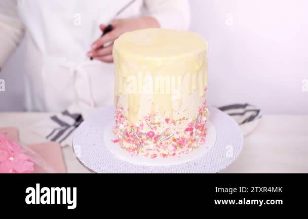 Step by step. Dripping a white chocolate ganache on birthday cake with ...